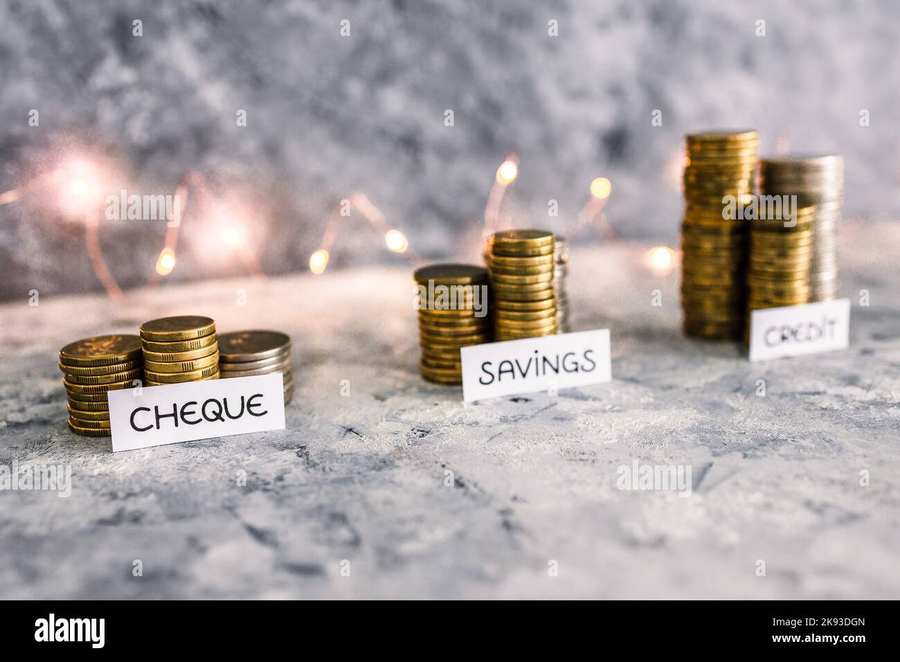 Cheque savings and credit account texts in front of growing stacks of ...