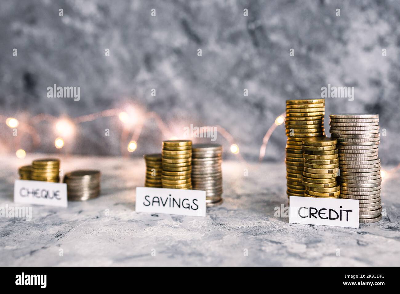 Cheque savings and credit account texts in front of growing stacks of ...