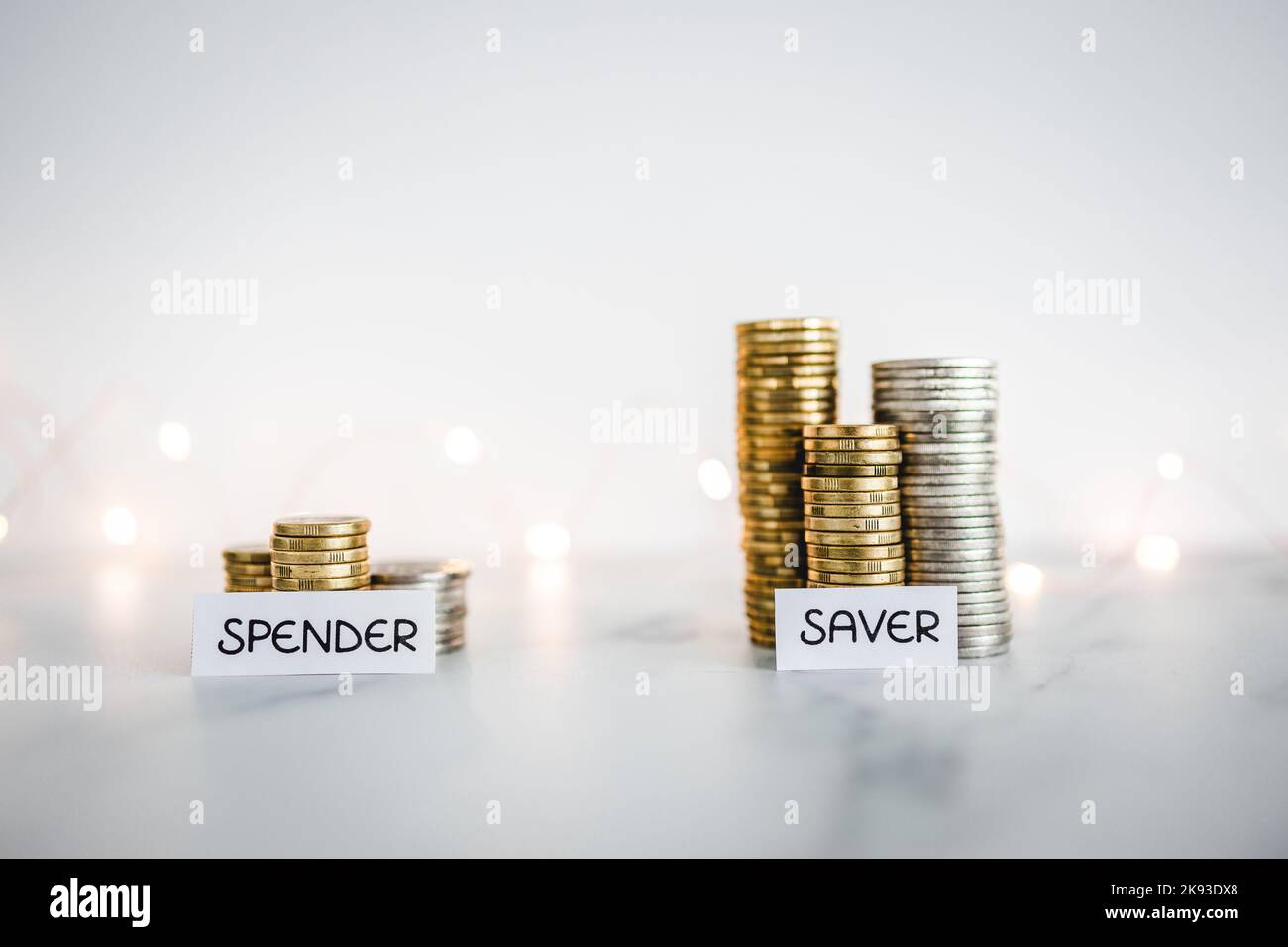 Saver vs spender texts in front of big and small stacks of coins ...