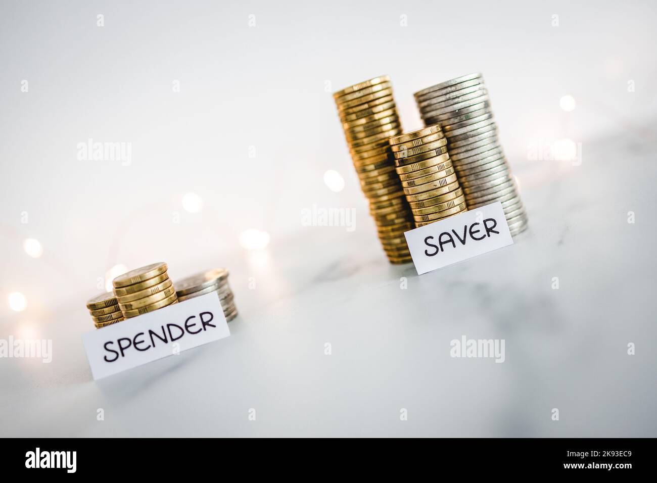 Saver vs spender texts in front of big and small stacks of coins ...