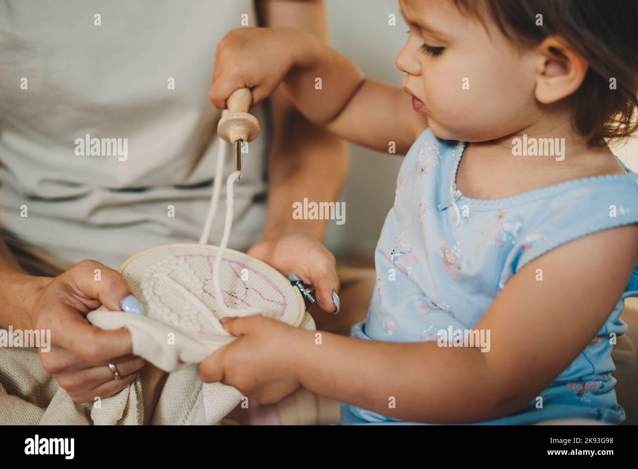 Baby girl learning hobby education in crafting at home with her mother ...