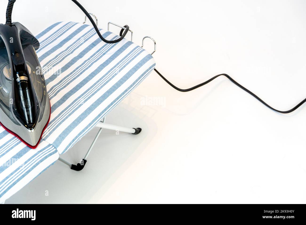 new clothes iron on white background, red ceramic iron, and blue fabric ...