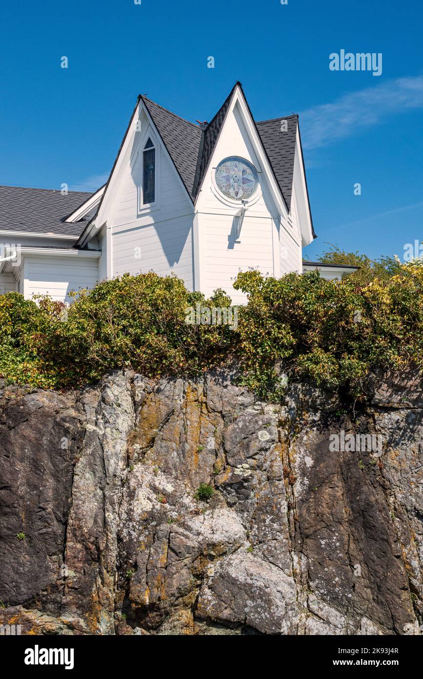 The white Emmanuel Episcopal church sits above a seaside cliff in ...