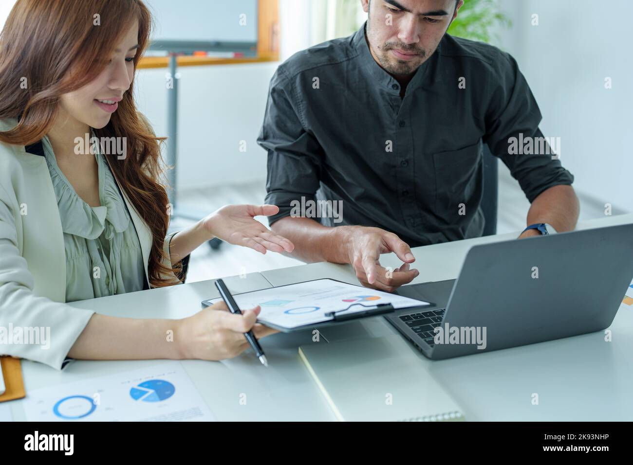 A portrait of a female marketer and a male salesperson discussing how ...