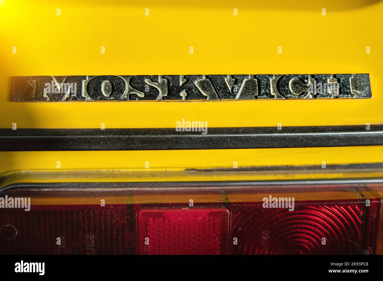 Moskvich logo on the trunk of a ussr yellow retro Moskvich car, close ...