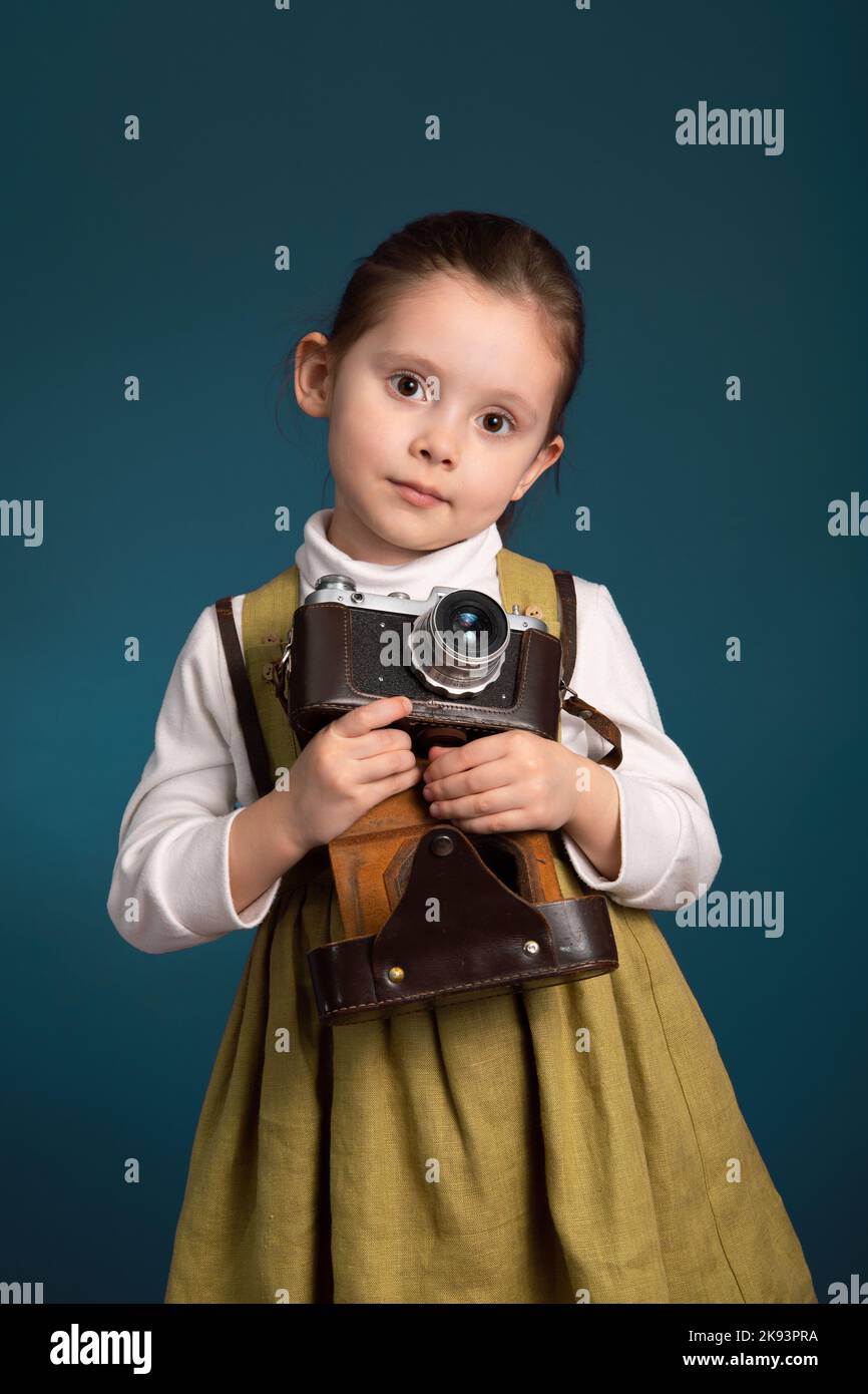 Cute little smiling girl photographer with retro camera. Studio ...