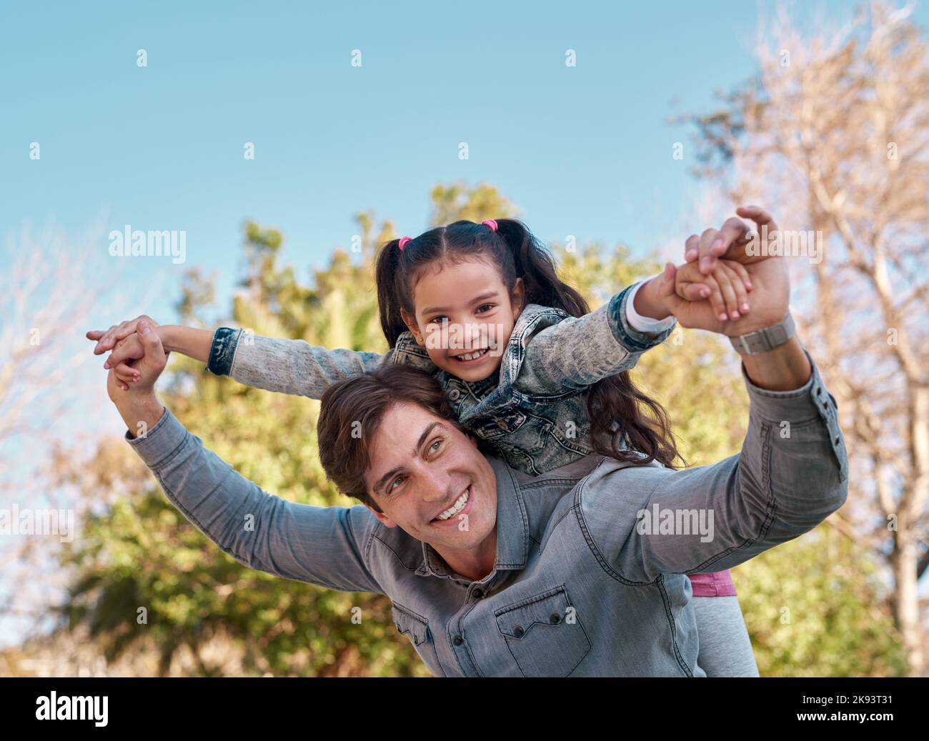 Look dad, Im flying. an adorable little girl enjoying a piggyback ride ...