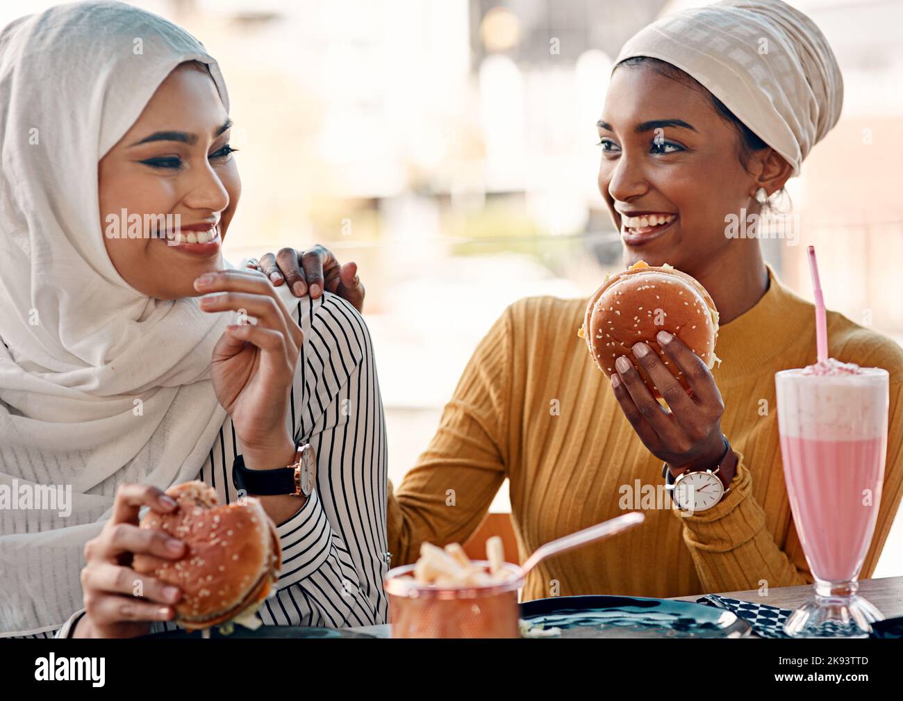 Two people sitting eating burgers hi-res stock photography and images ...