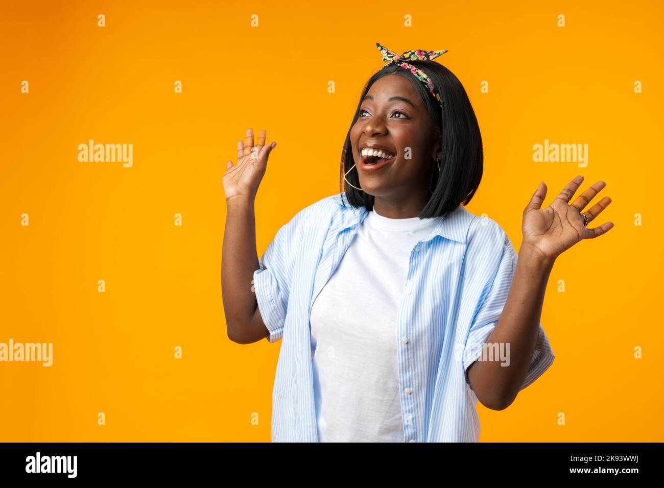 Surprised happy young african woman express shock against yellow ...