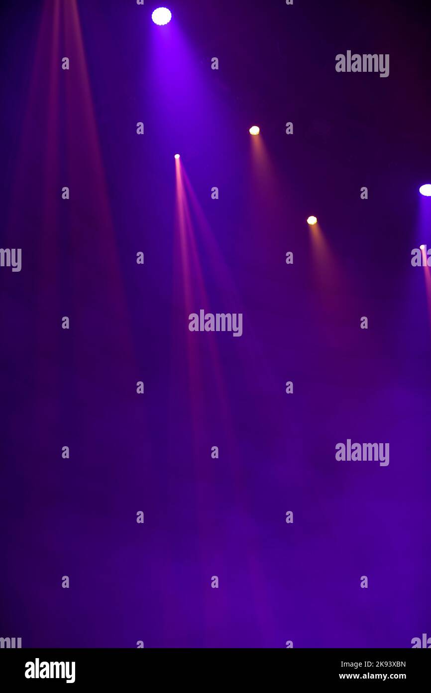 Purple beams of light from stage spotlights on a dark background Stock ...