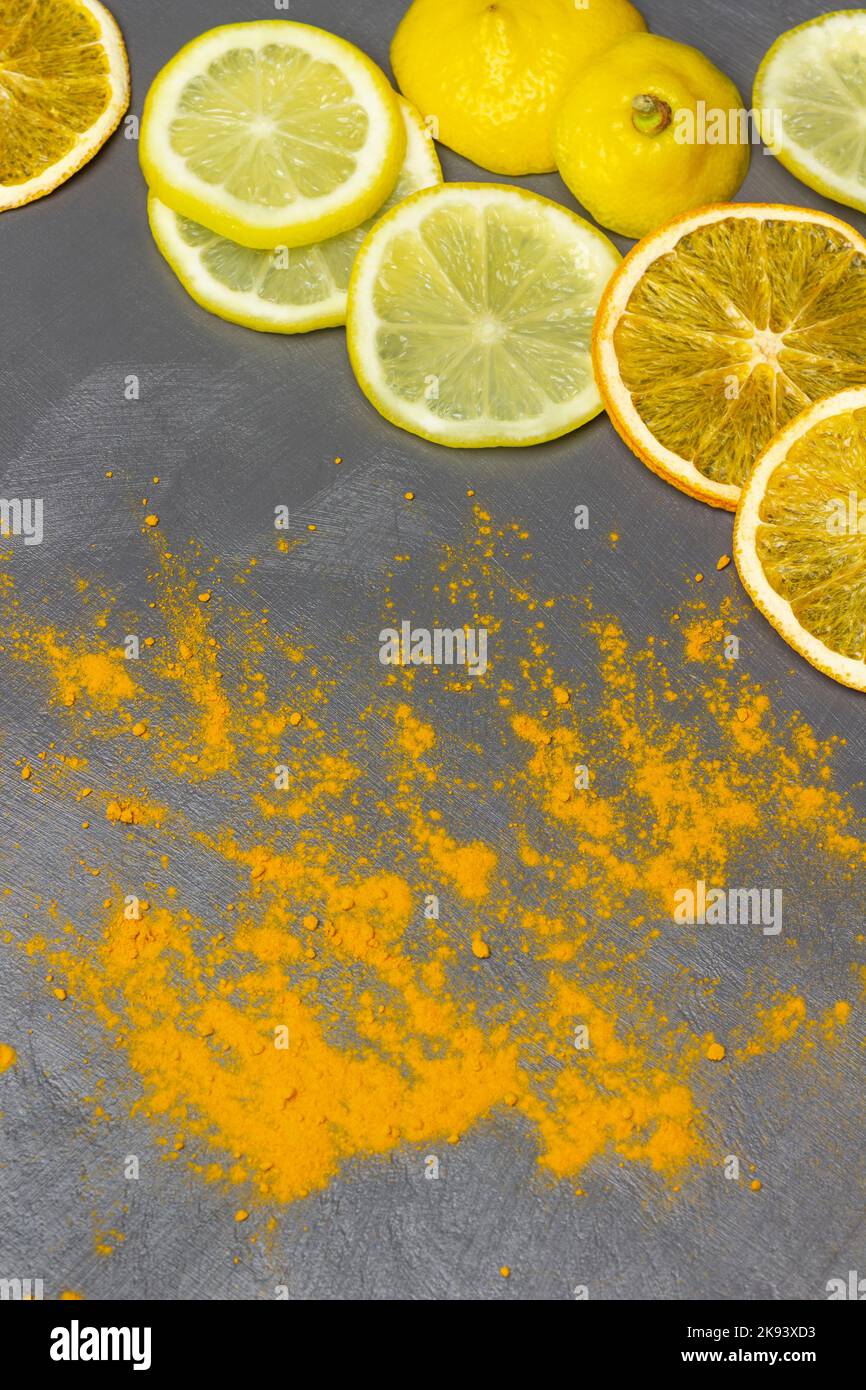 Dry orange slices, chopped lemon and turmeric on the table. Flat lay ...