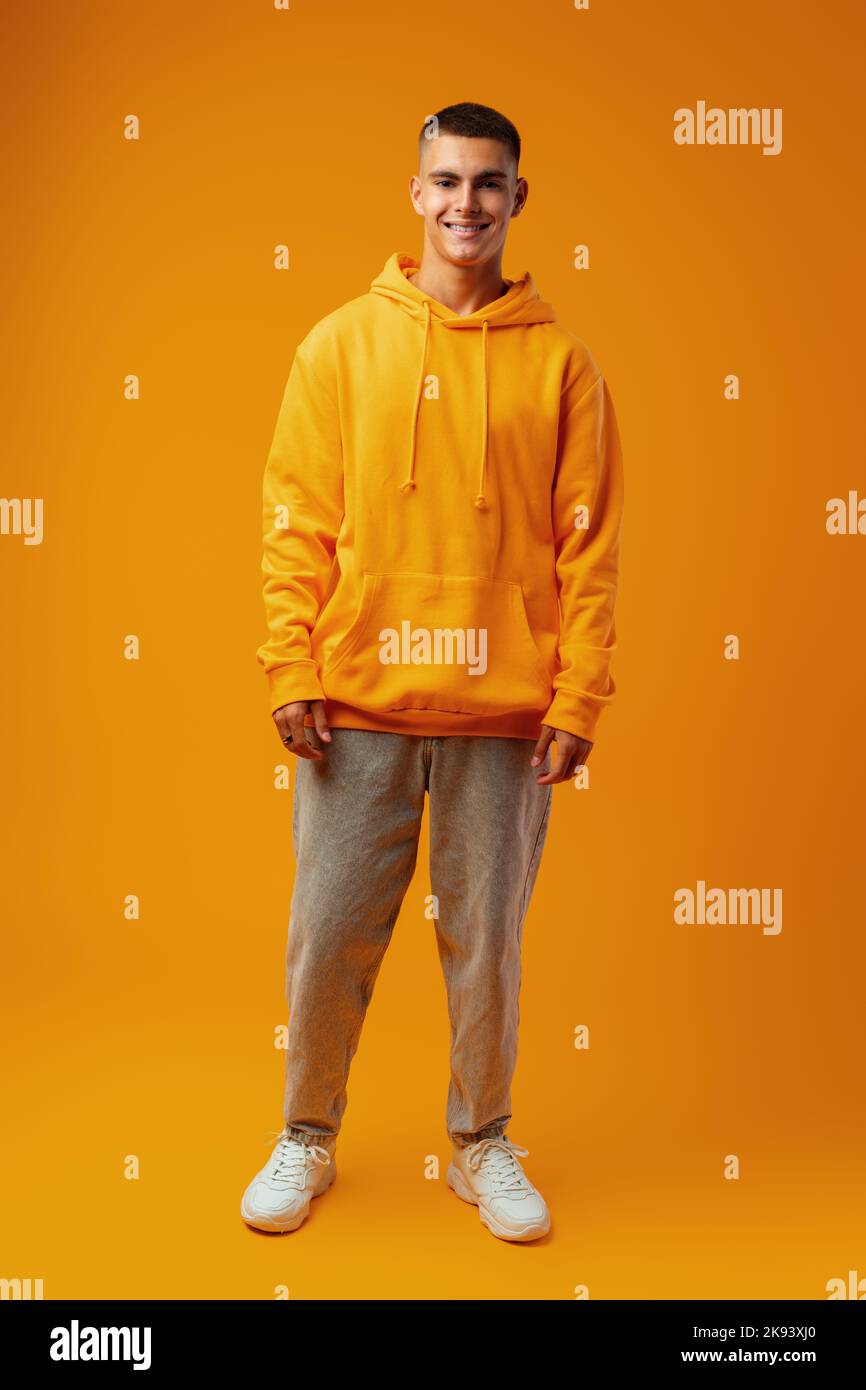 Full length portrait of young man standing on yellow background Stock ...