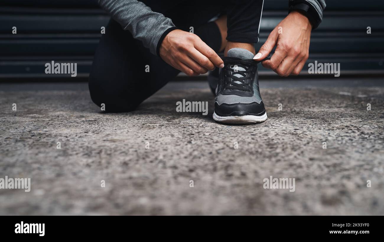 I am ready. an unrecognizable woman crouched down and tying her shoes ...