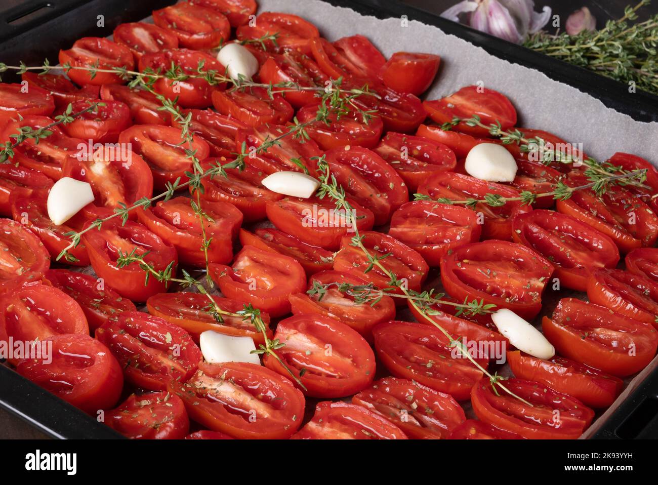 Tomatoes laid out on a baking sheet for cooking in the oven Stock Photo ...