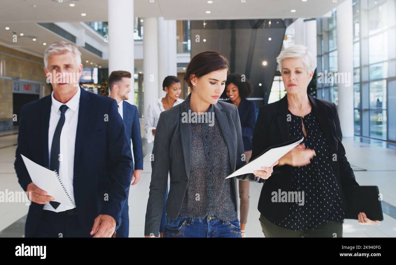 Checking the projections for the day. a diverse group of businesspeople ...