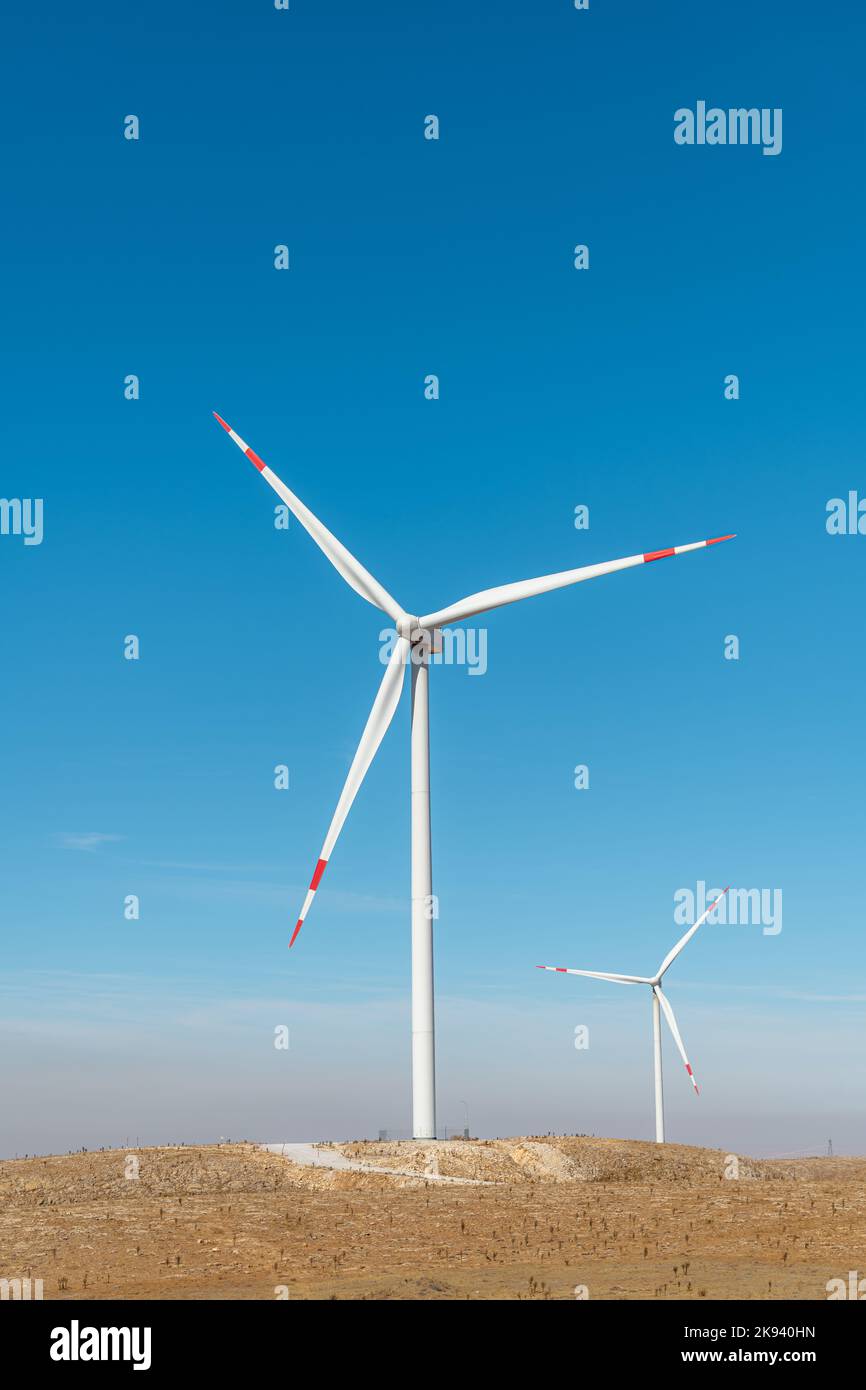 Multiple wind turbines standing on a hill at sunrise and generating ...