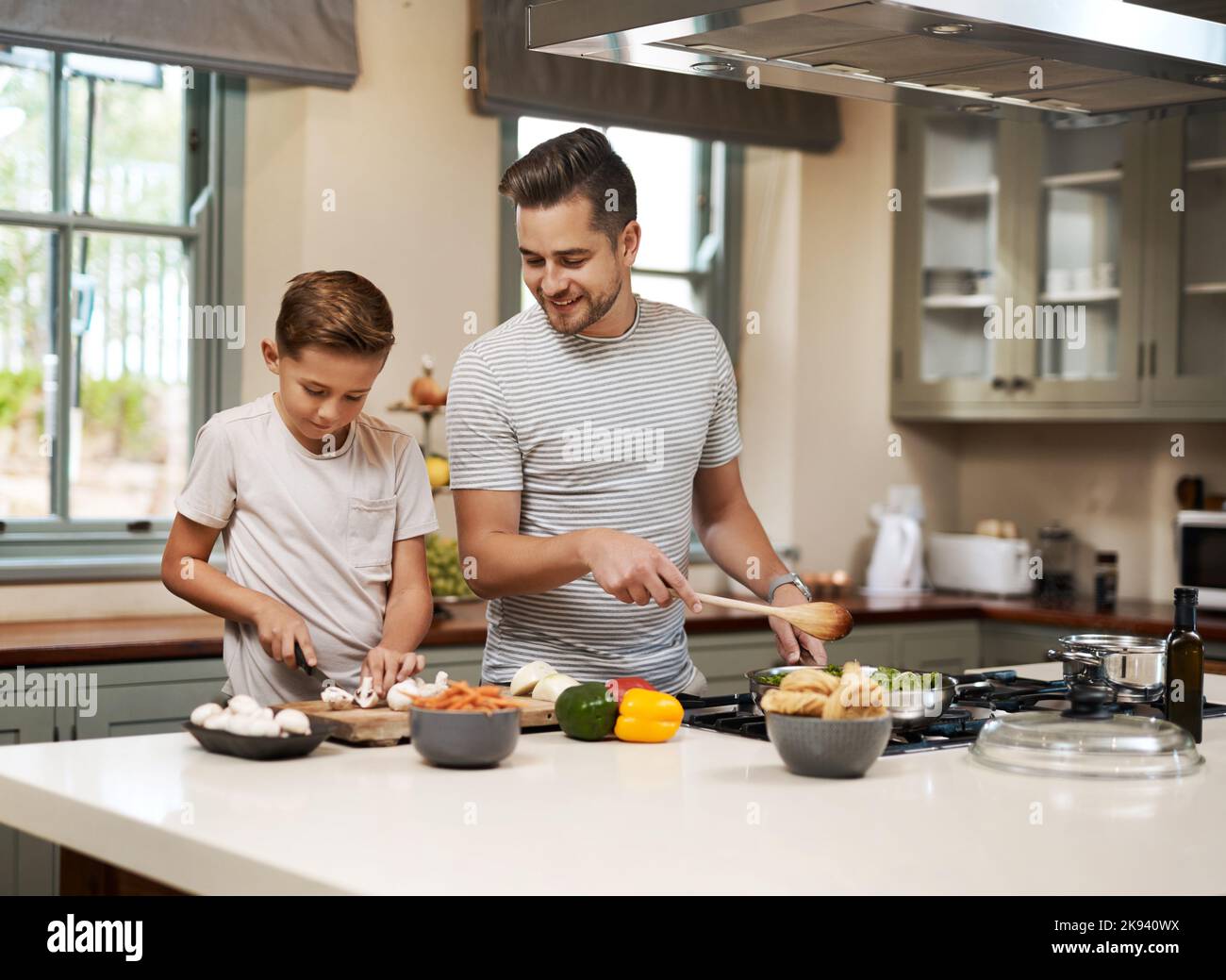 Are you ready with those mushrooms. a young boy helping his father cook ...