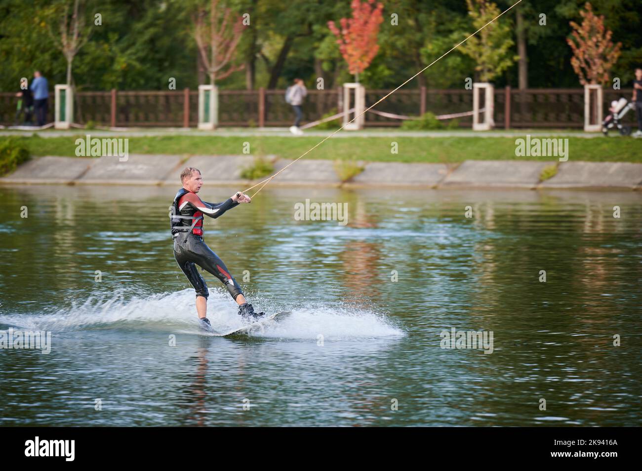 Wakeboarder surfing on lake. Young man surfer having fun wakeboarding ...