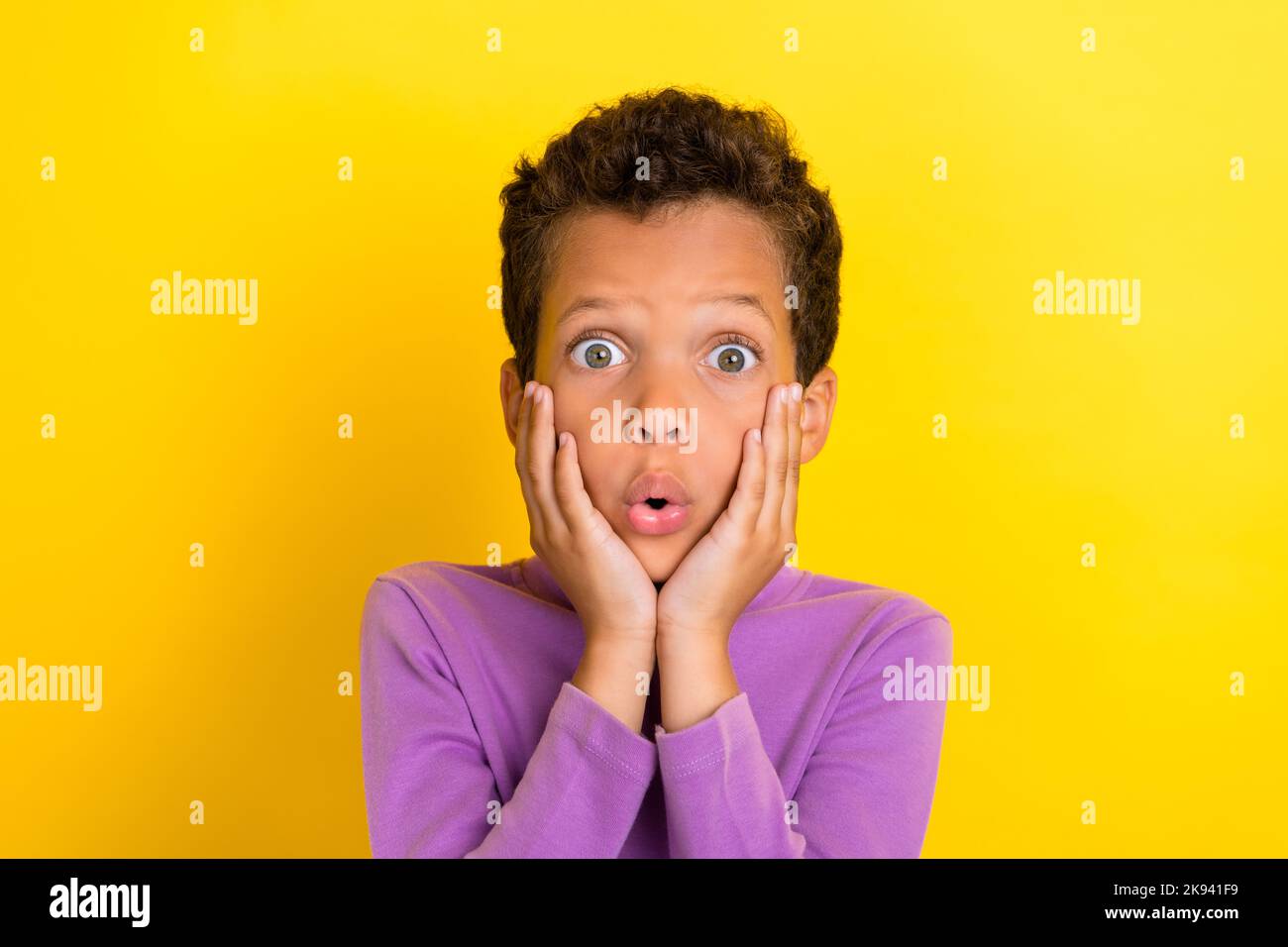 Portrait of impressed boy pouted lips hands touch cheeks isolated on ...