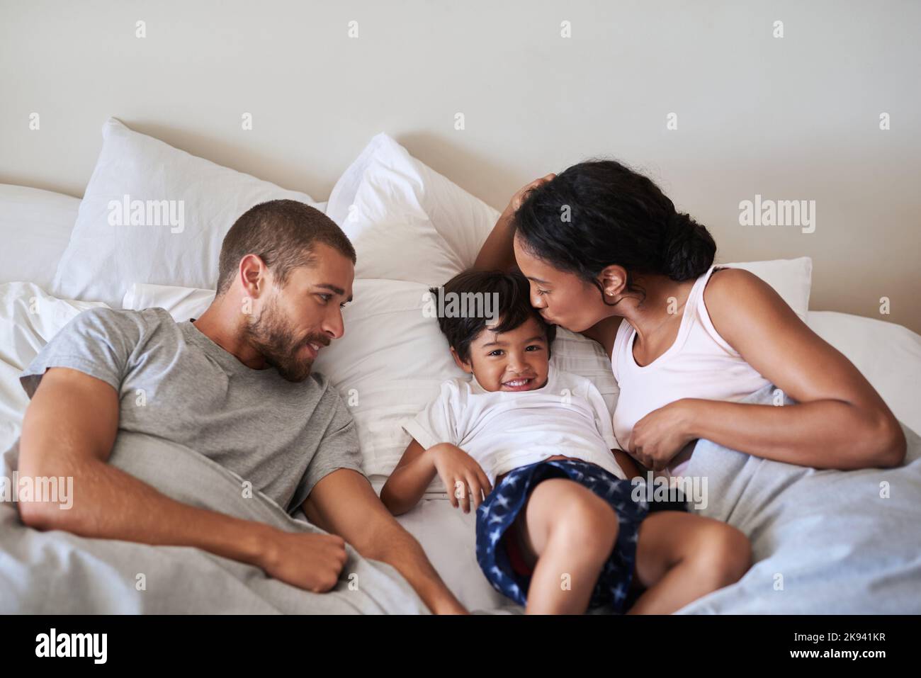 Son kissing mother in bed hi-res stock photography and images - Alamy