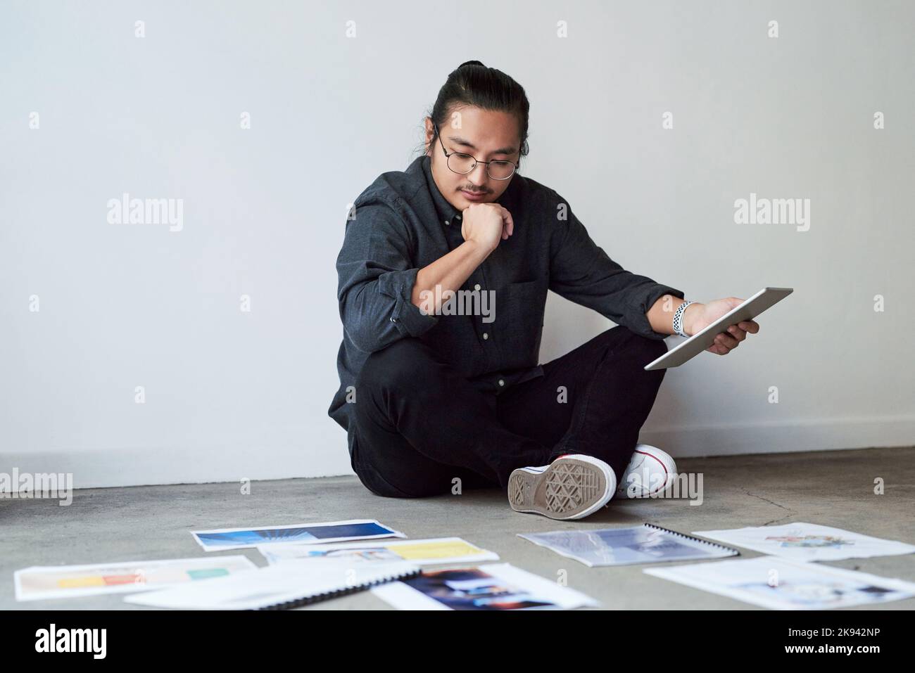 Giving this some careful thought. Full length shot of a creative young ...