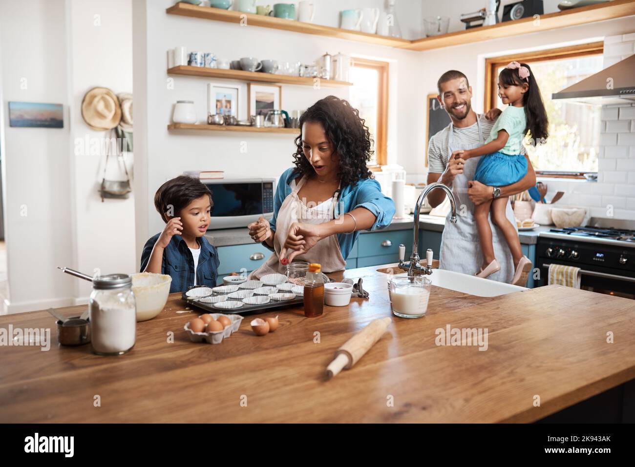 Adding some fruitiness. a young family spending quality time together in the kitchen at home ...