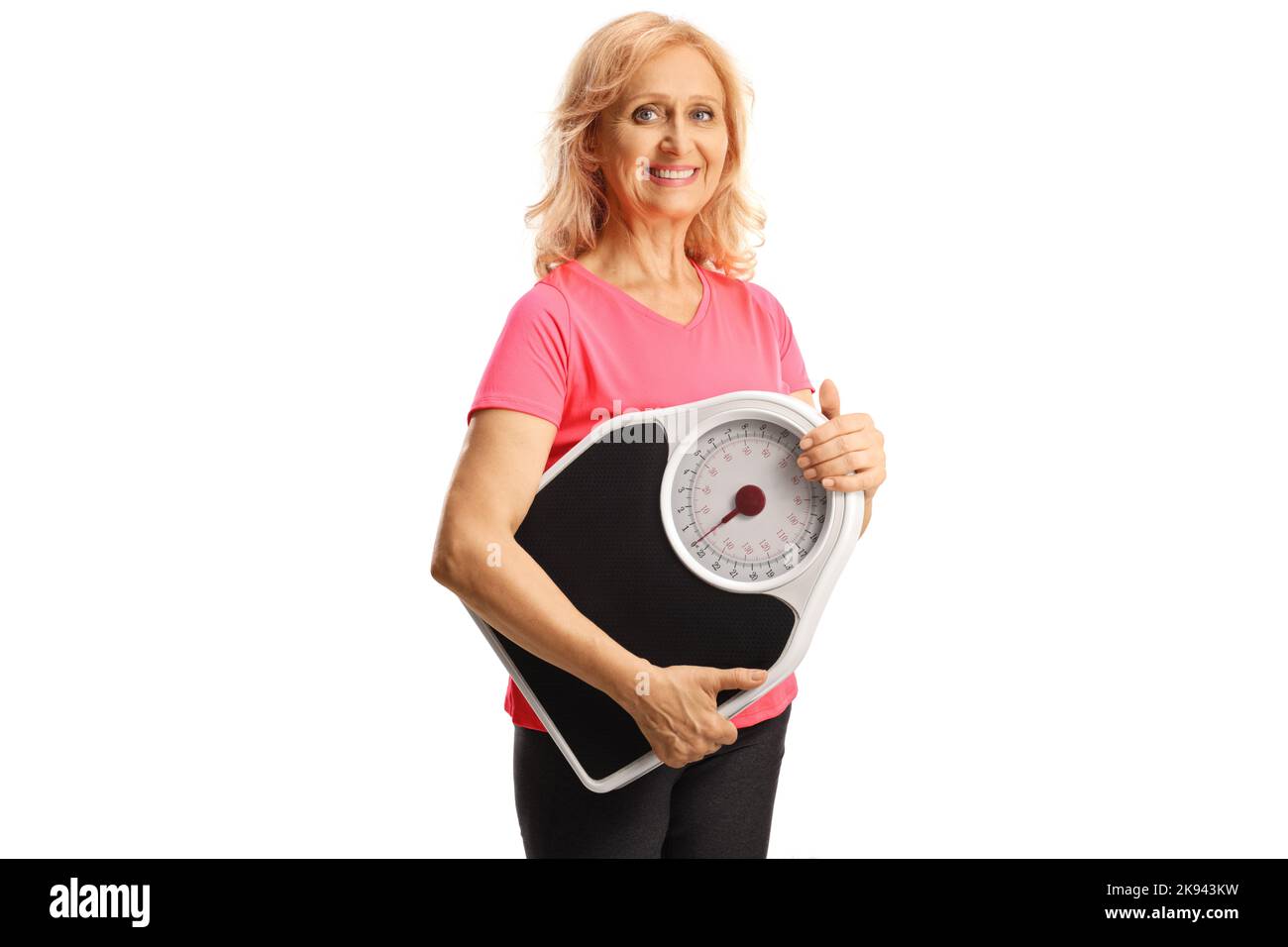 Smiling mature woman in sportswear holding a measuring scale isolated ...