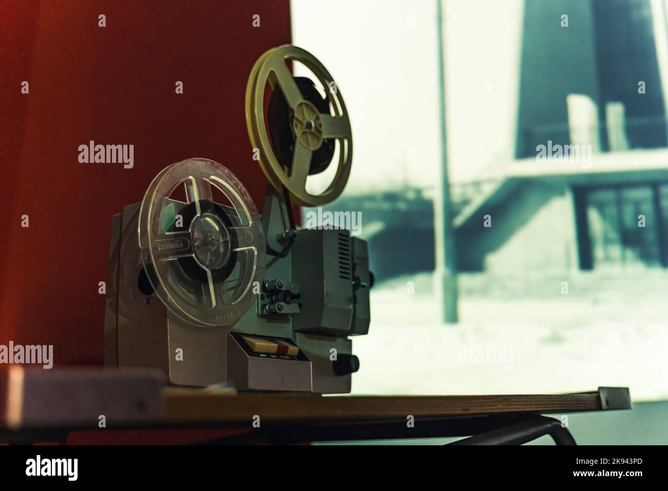 White old-fashioned film projector showing a movie out of film. The ...