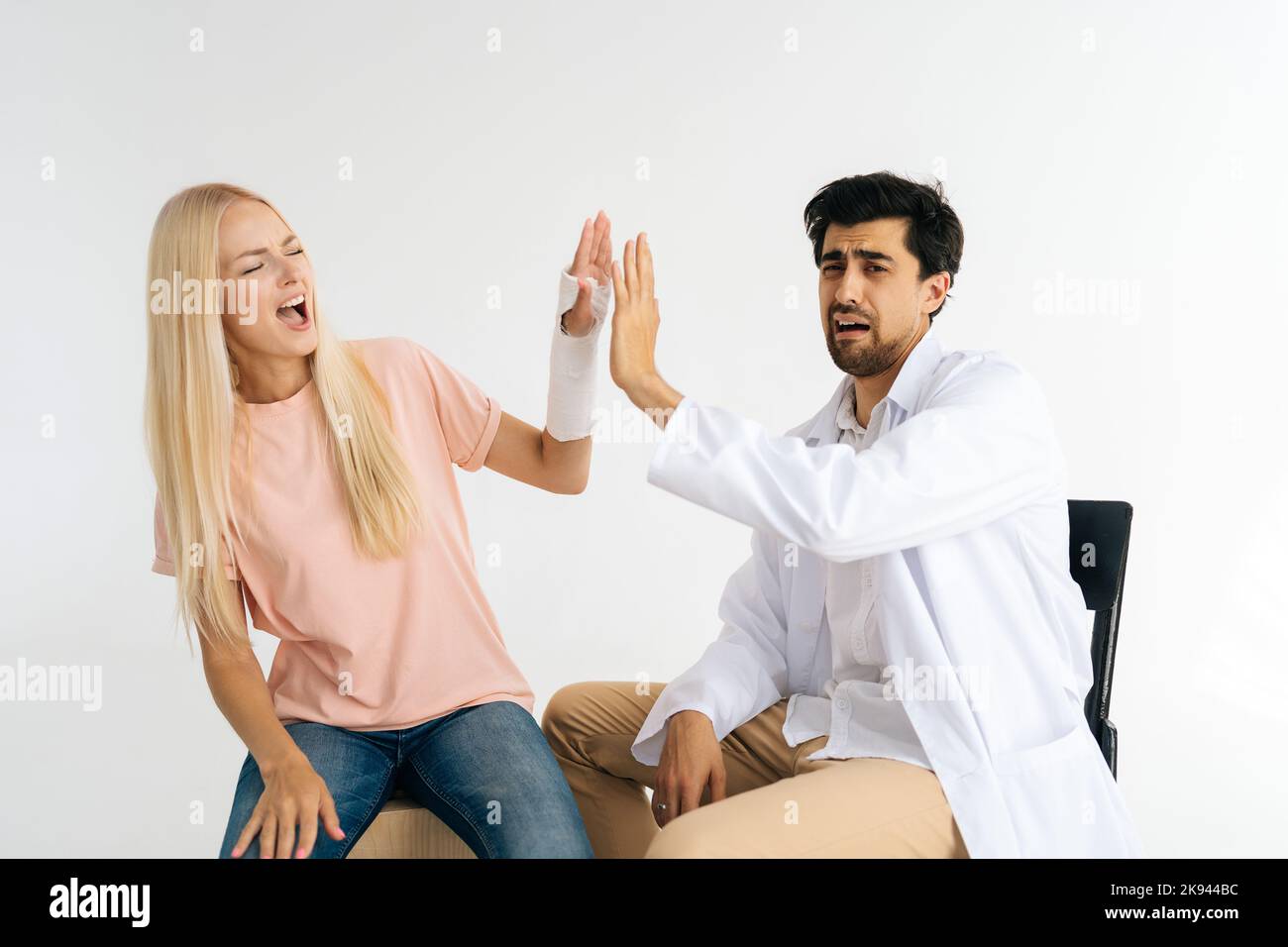 Funny male doctor give high five to cheerful female patient with broken ...