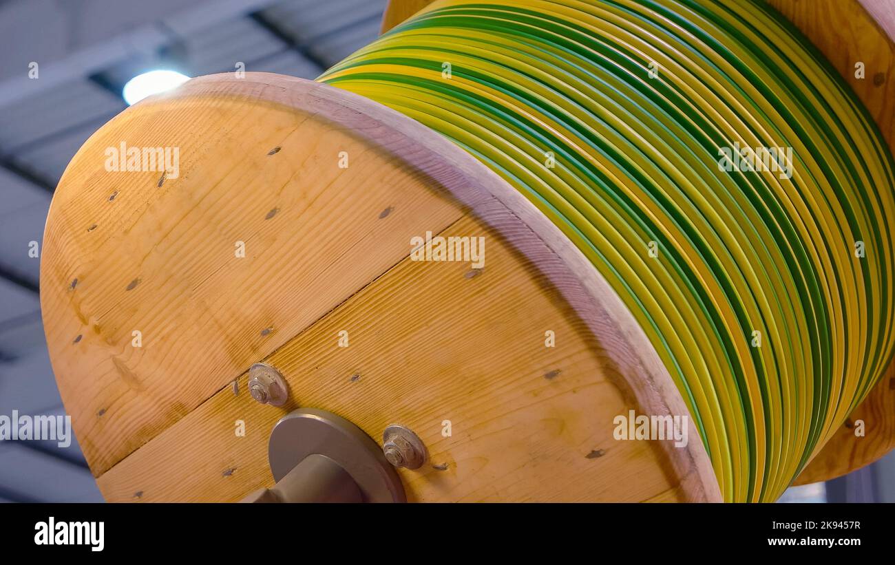 Close-up wooden coil of electric cable indoor. High and low voltage ...