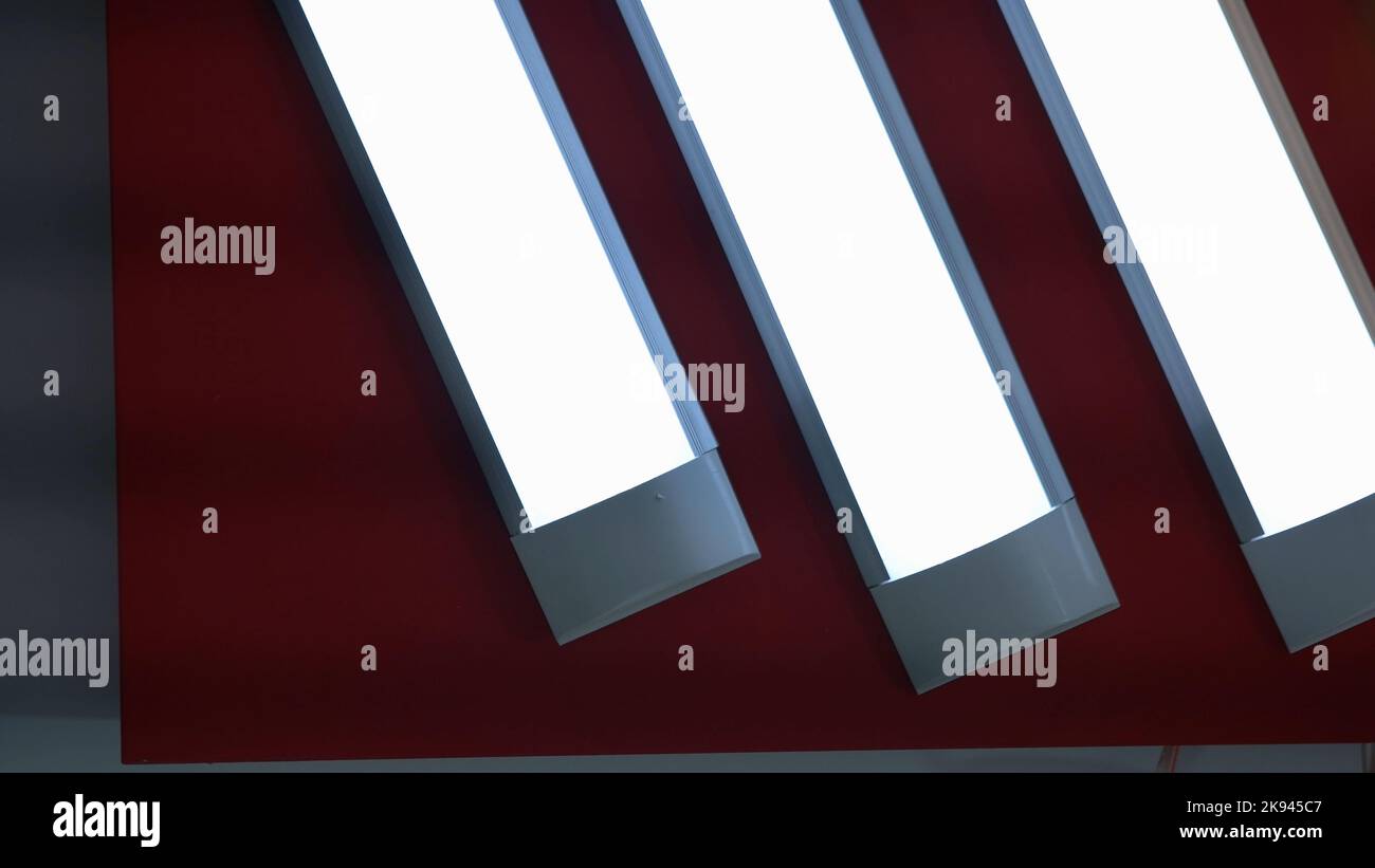 Horizontal long lamps on the red ceiling. Room illumination technology ...
