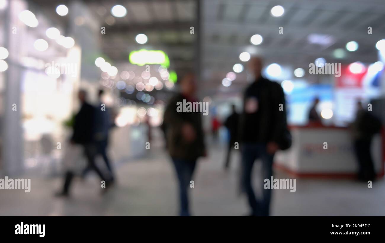 Blurred crowds of walking people indoors in the mall. Many random ...