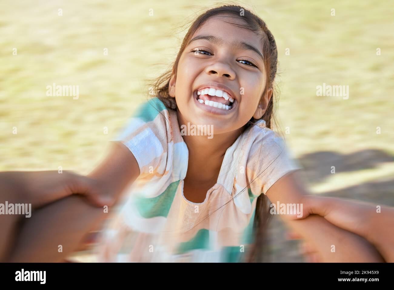 Face of happy girl swinging and spinning in circles by the arms at the ...