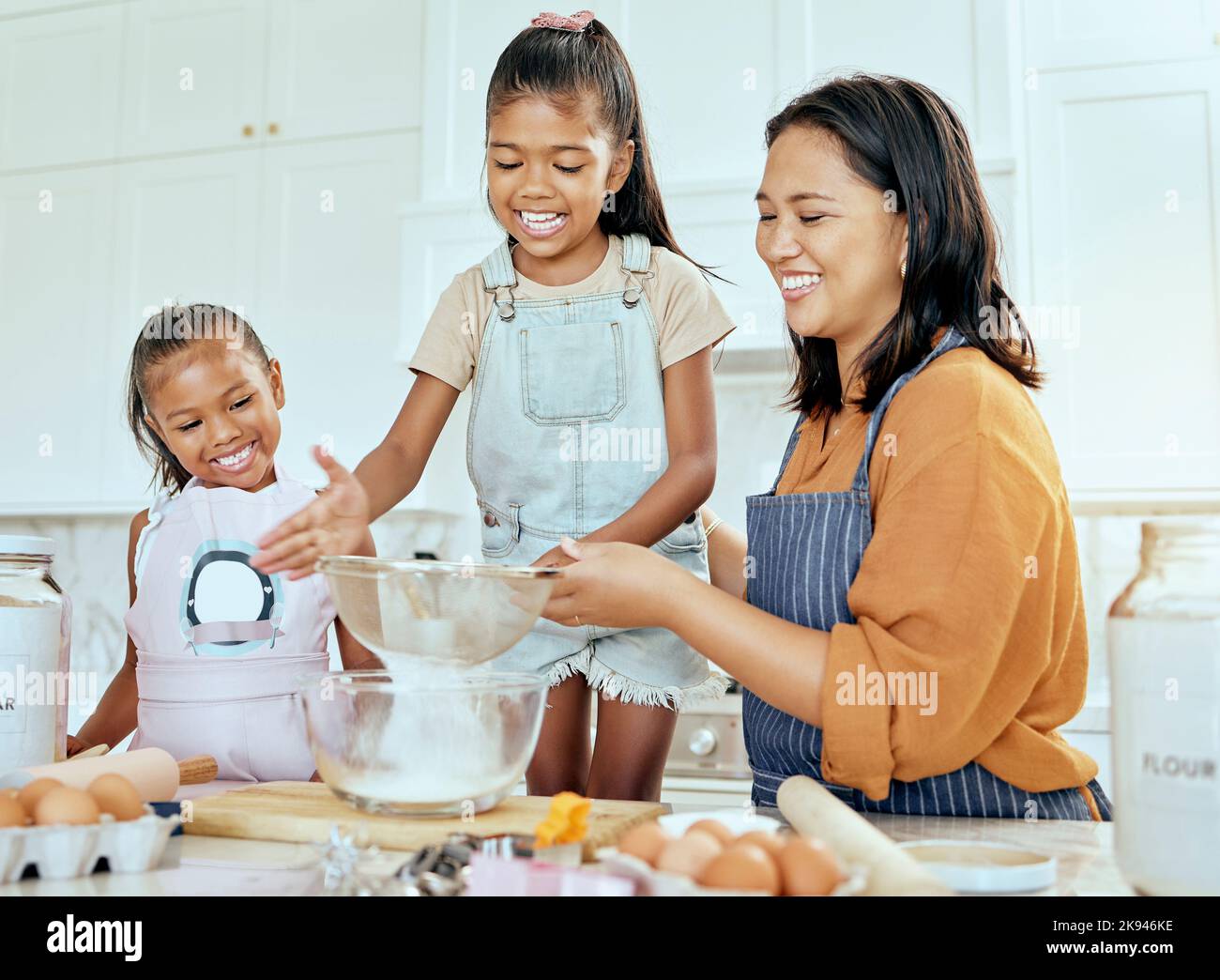 Happy family cooking, mother and children help mom with egg, wheat ...