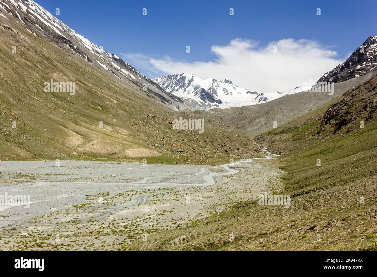 A beautiful glacier fed river flowing through the mountains of the ...