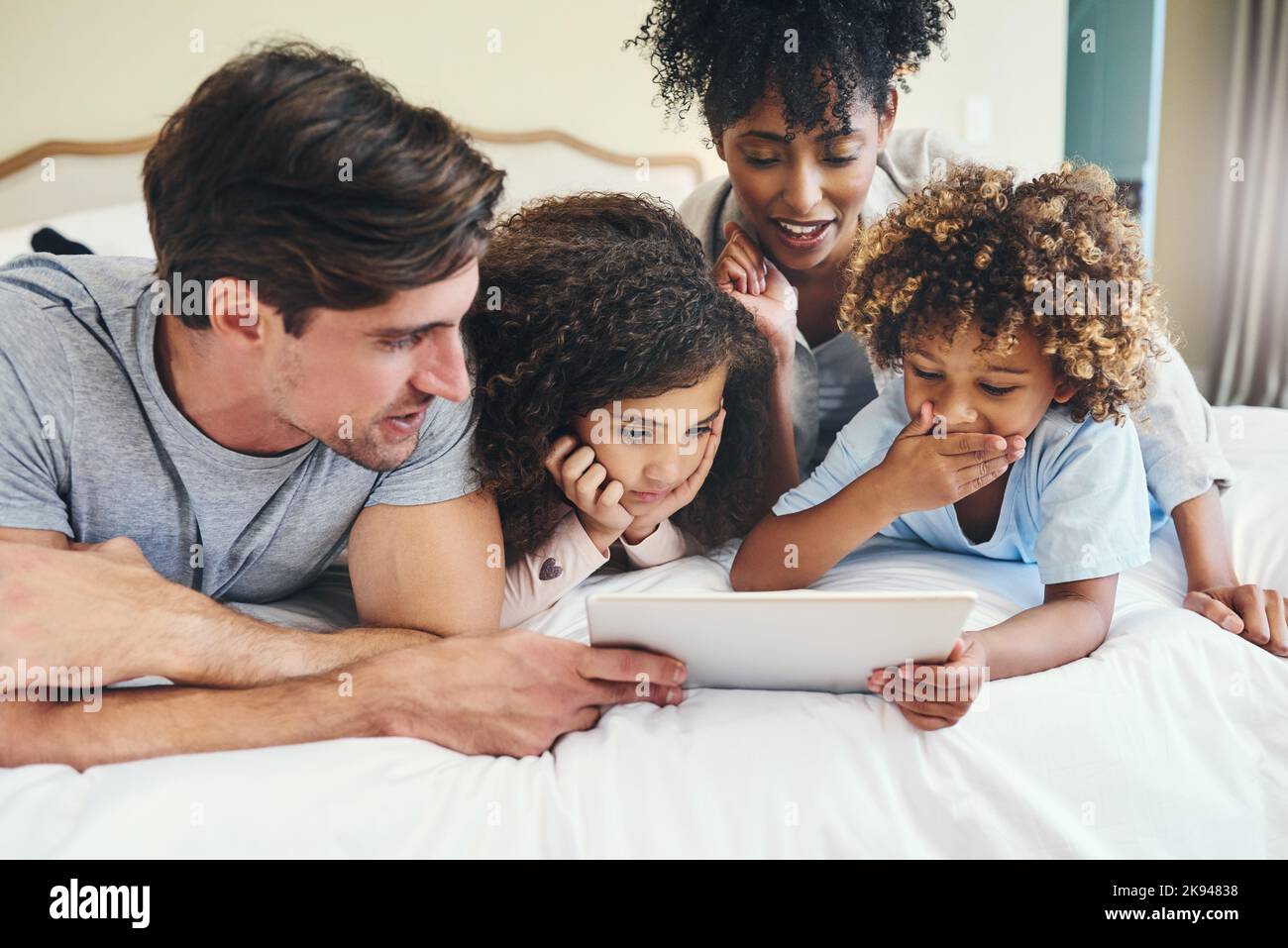 Early morning cartoons are their thing. a family using a digital tablet together at home Stock ...