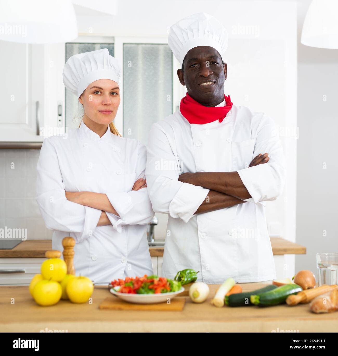 Two smiling confident personal chefs in white uniforms standing in ...