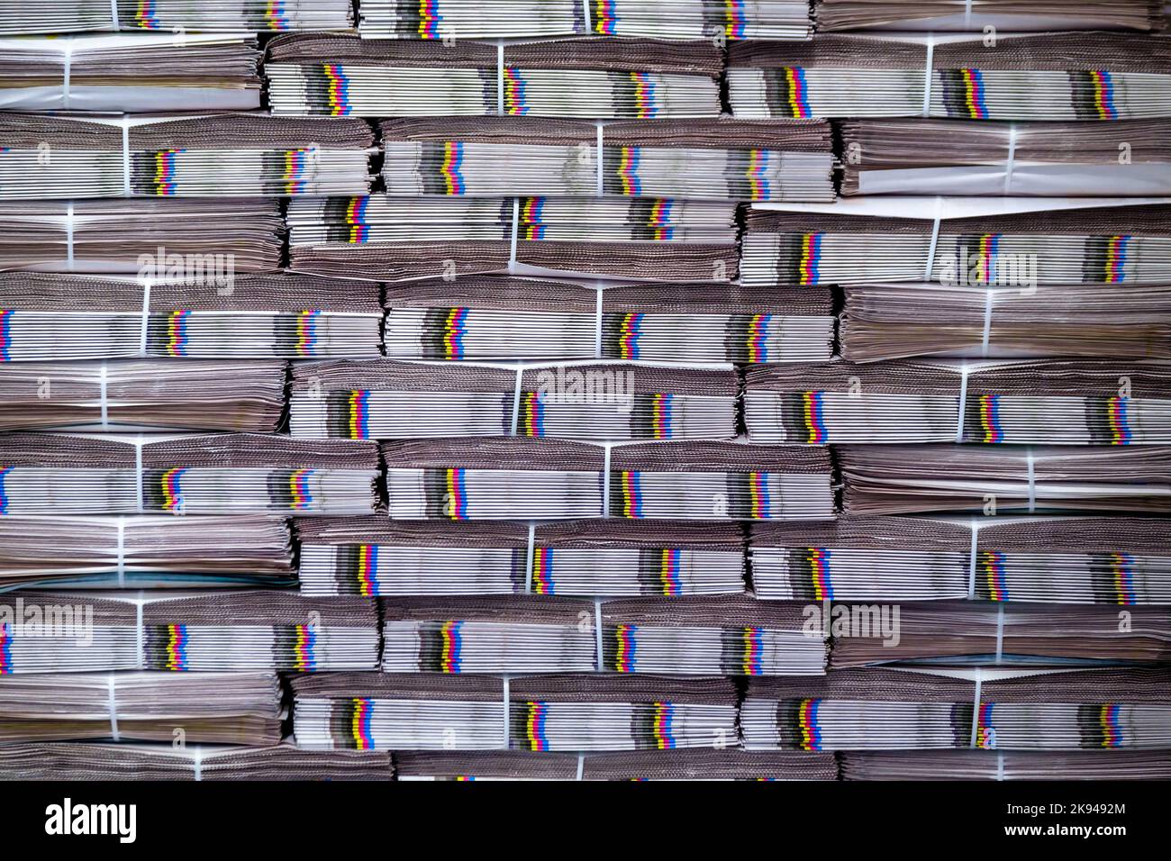 Heaps of newspapers with colorful pages stacked on shelves in storage ...