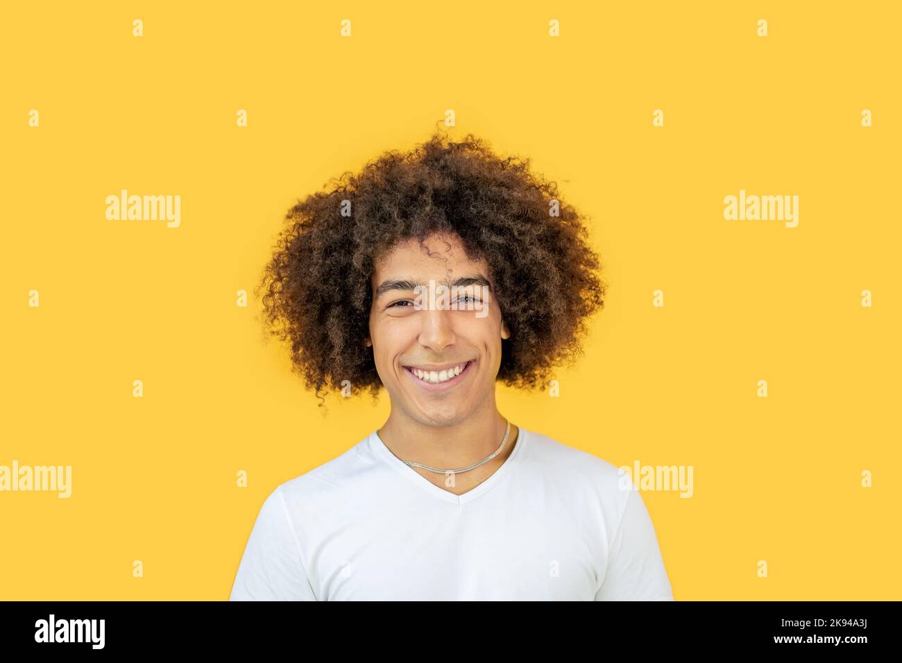 Portrait smiling young people of mixed race african-Italian on a yellow ...