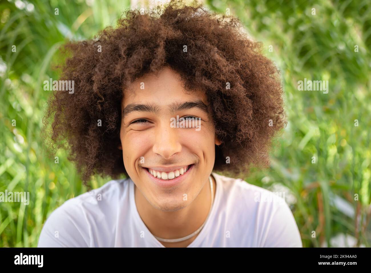 Portrait of a smiling young mixed race Afro-Italian man outdoors ...