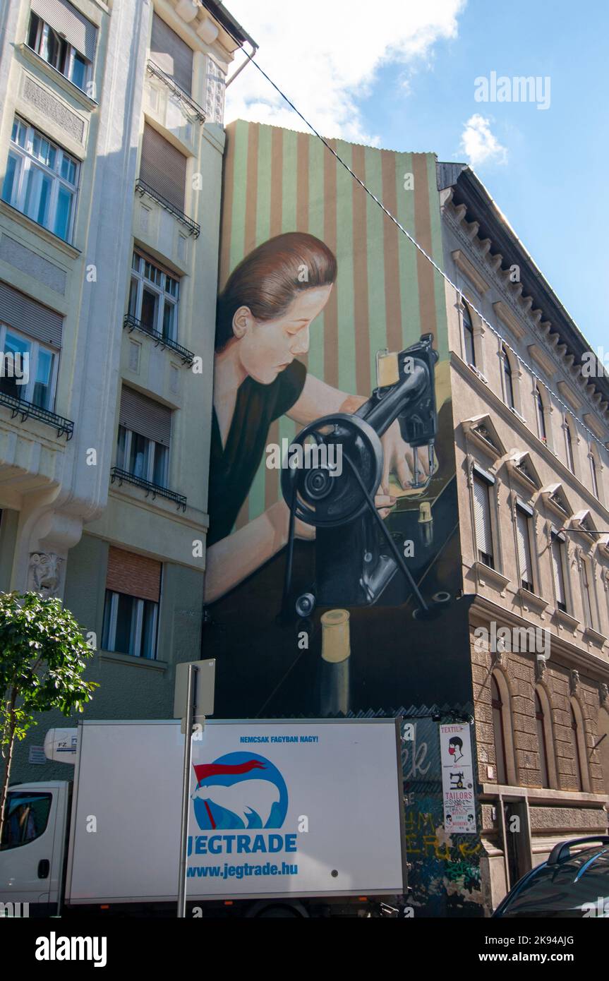 Graffiti of woman sewing on a old style sewing machine. Graffiti on an ...