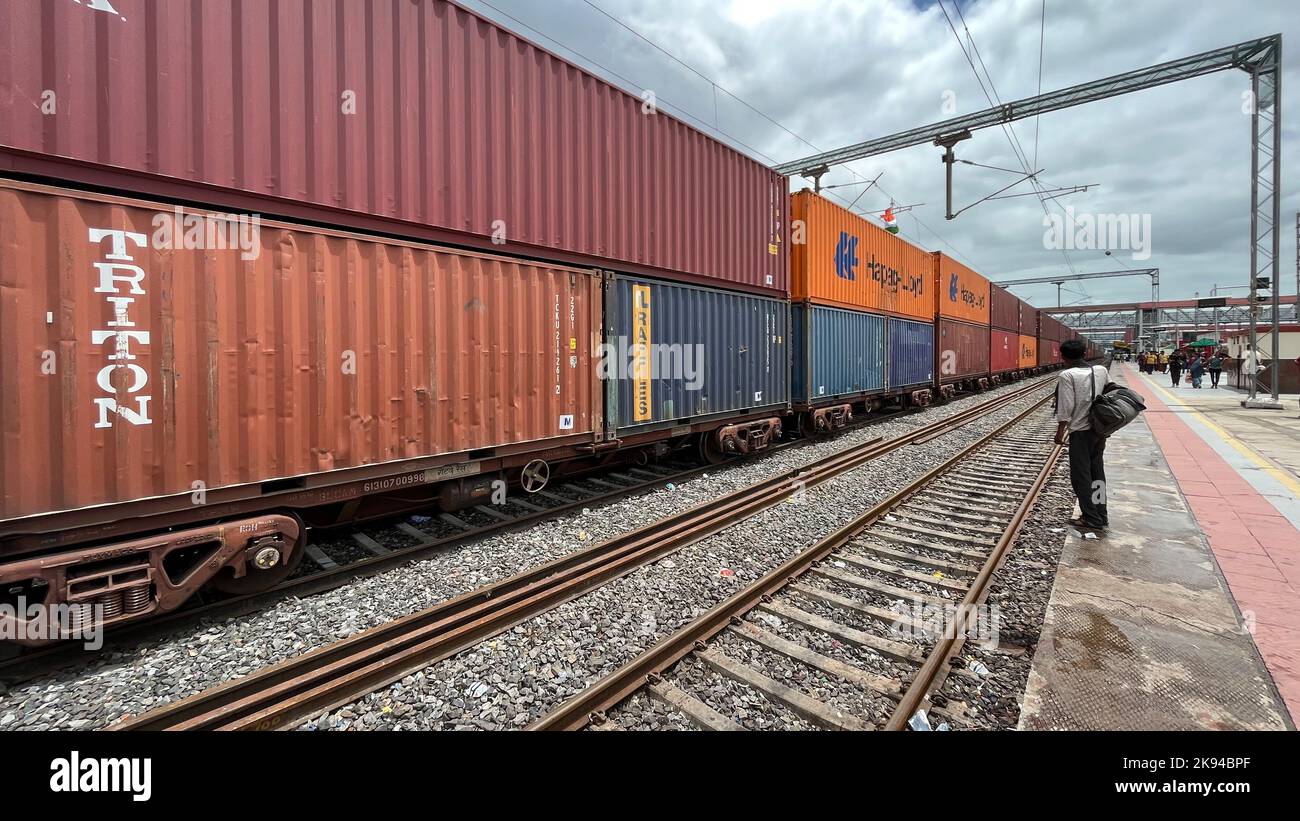 A Double decker Cargo train Stationary with a passenger waiting for a ...