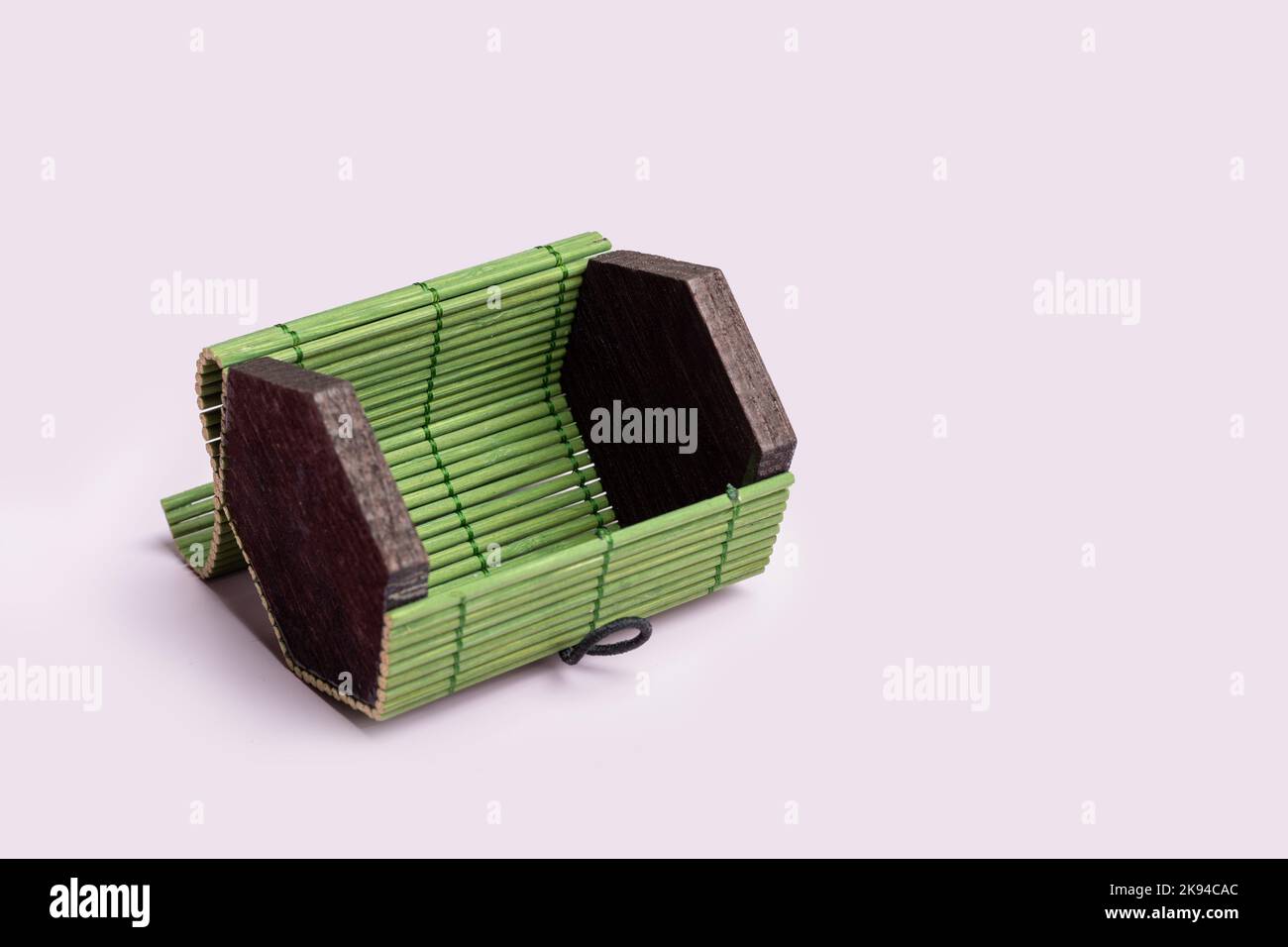 Empty open green small wicker chest, container on a soft pink ...