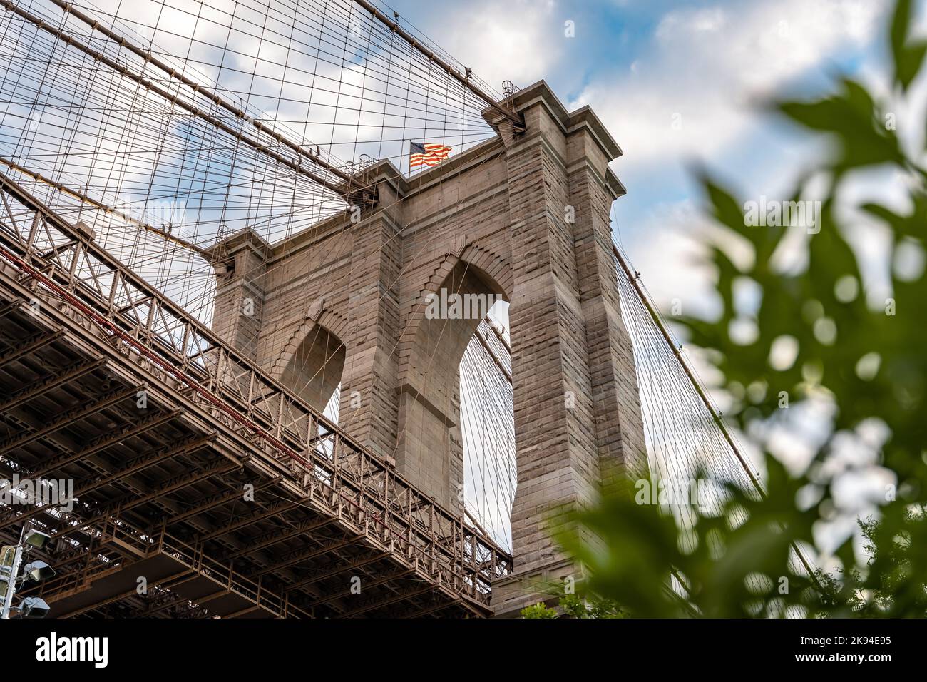 A low angle of the Brooklyn Bridge in New York City with the American ...