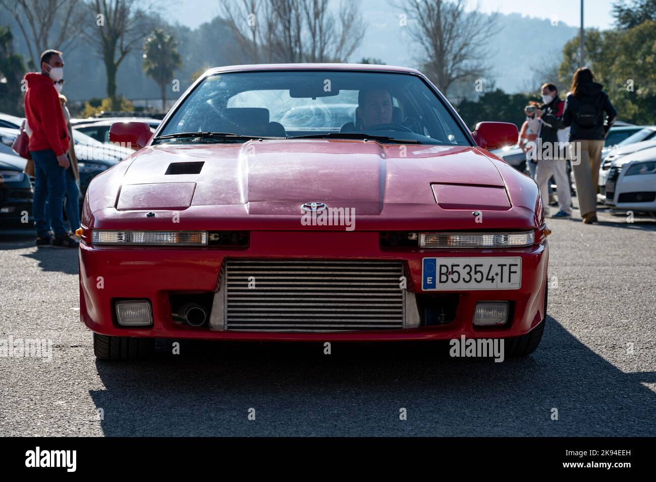 A front view of a red third-generation Toyota Supra A70 car with a man ...