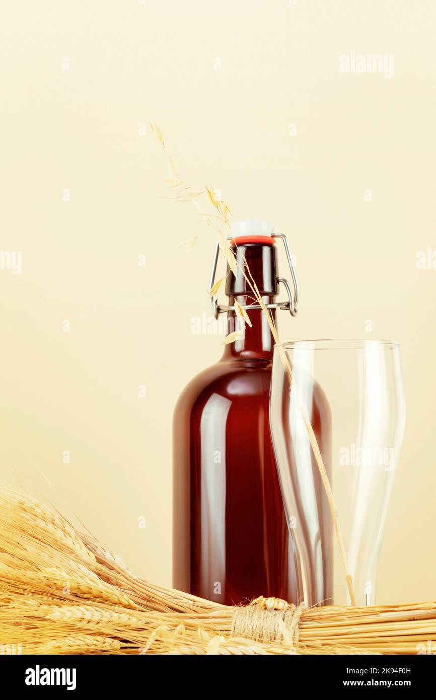 Bottle of natural home made beer and empty glass with bouquet of rye ...