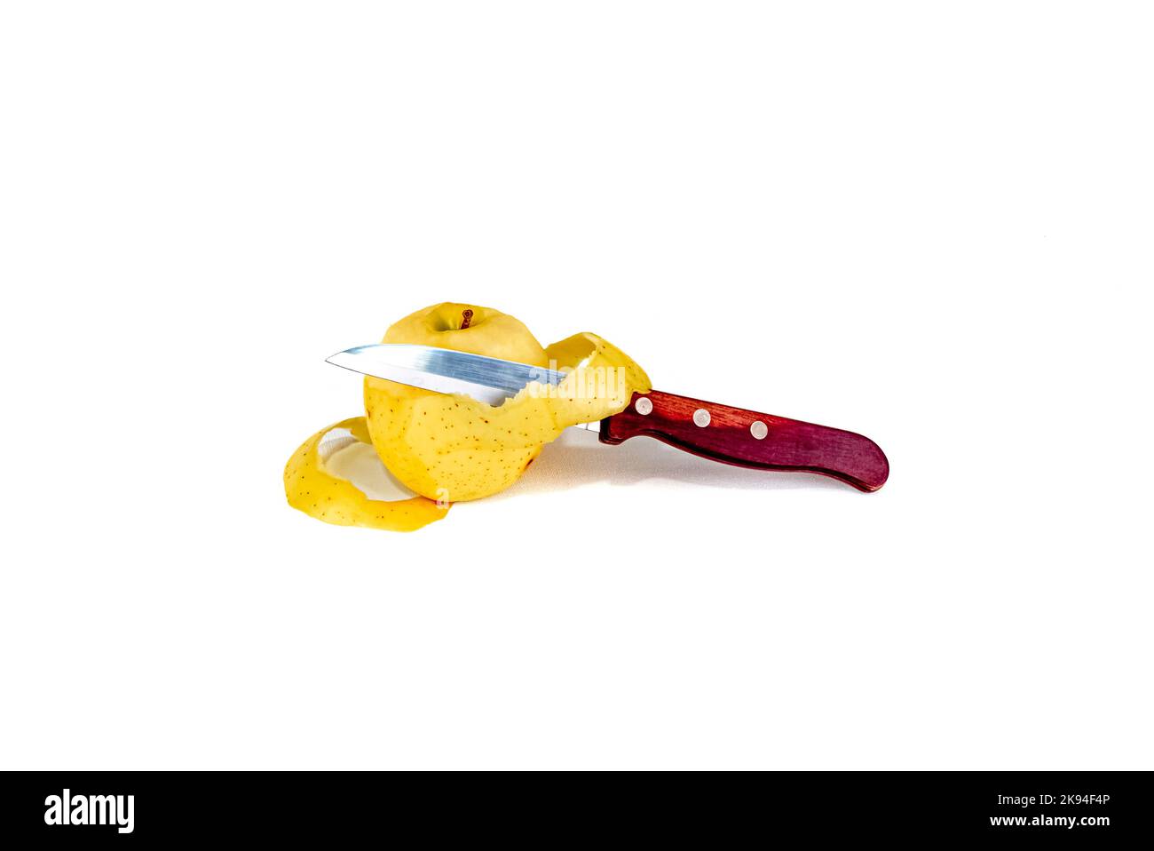 Apple peeling with red knife on white background. Close up Yellow ...