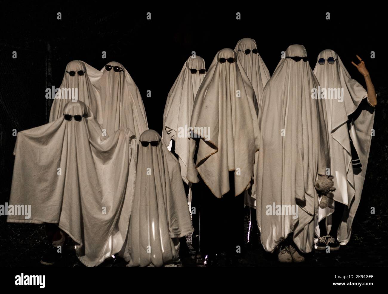 A group of people wearing ghost costumes against dark background Stock ...