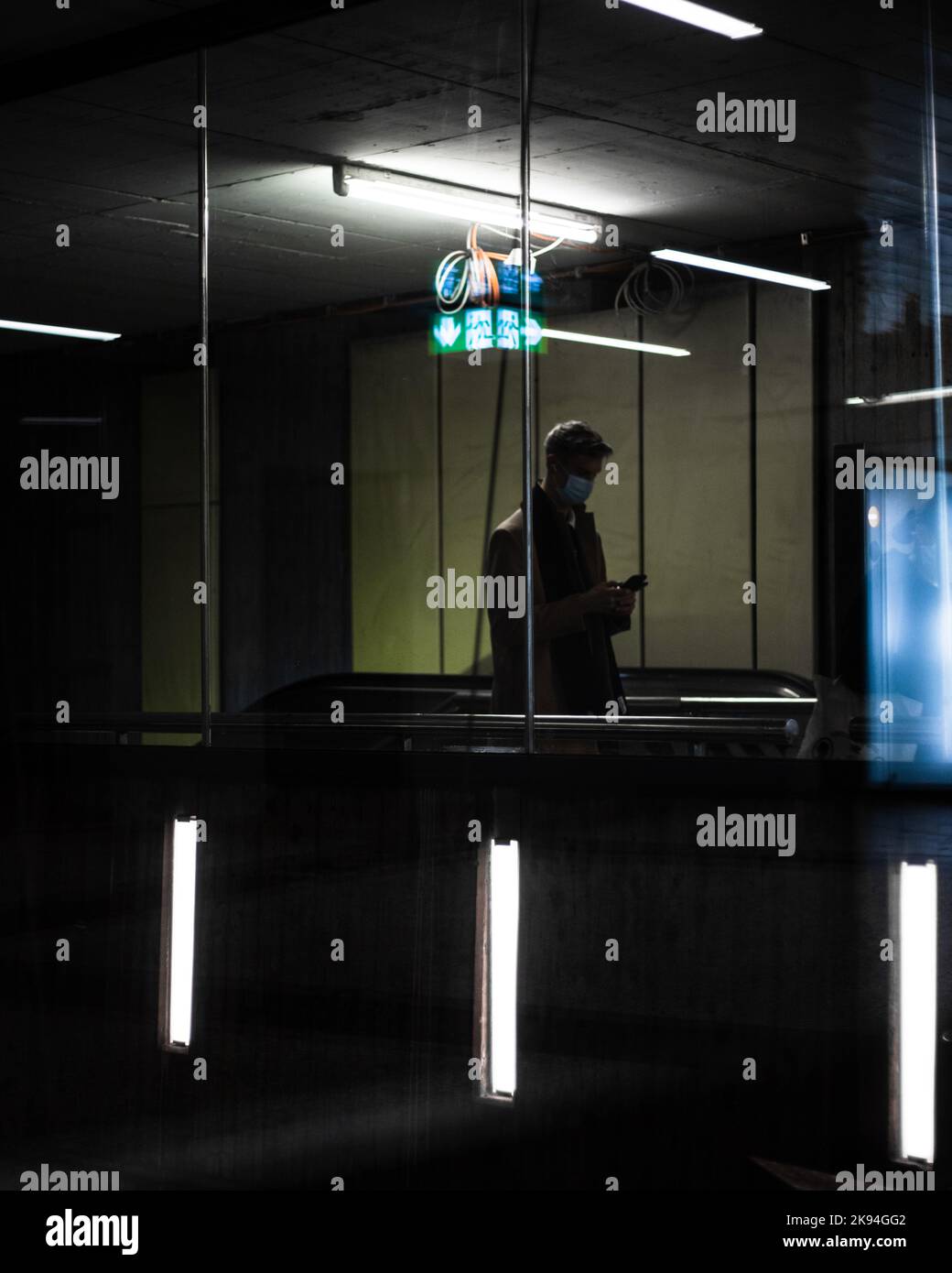 A male riding the escalator at an underground train station in ...