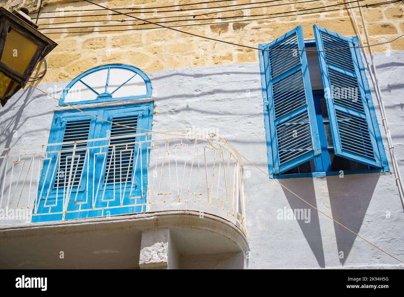 A low angle of a balcony with blue window shutters on brick wall Stock ...